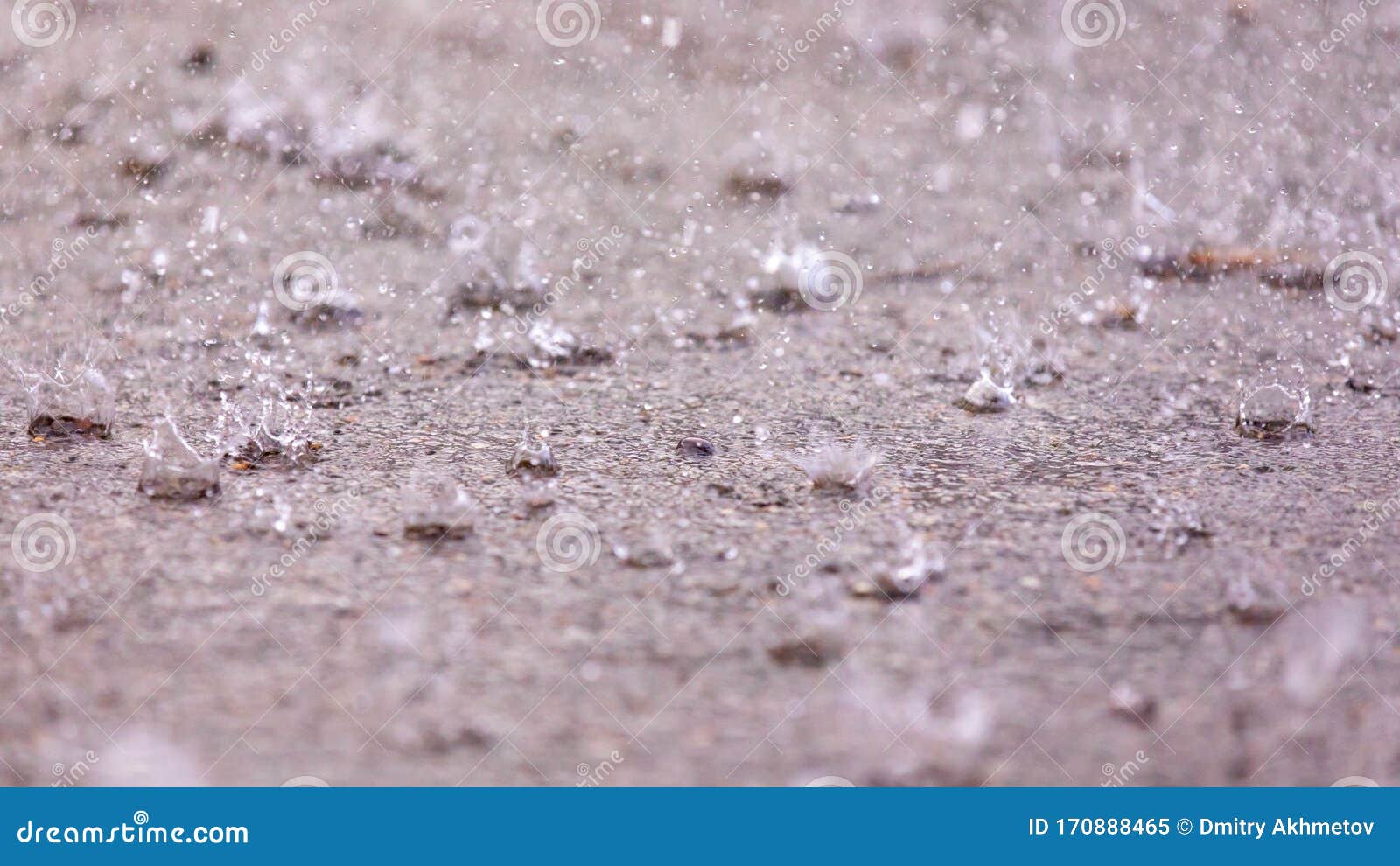 Large Raindrops Create Multiple Splashes on a Concrete Patio on of a ...