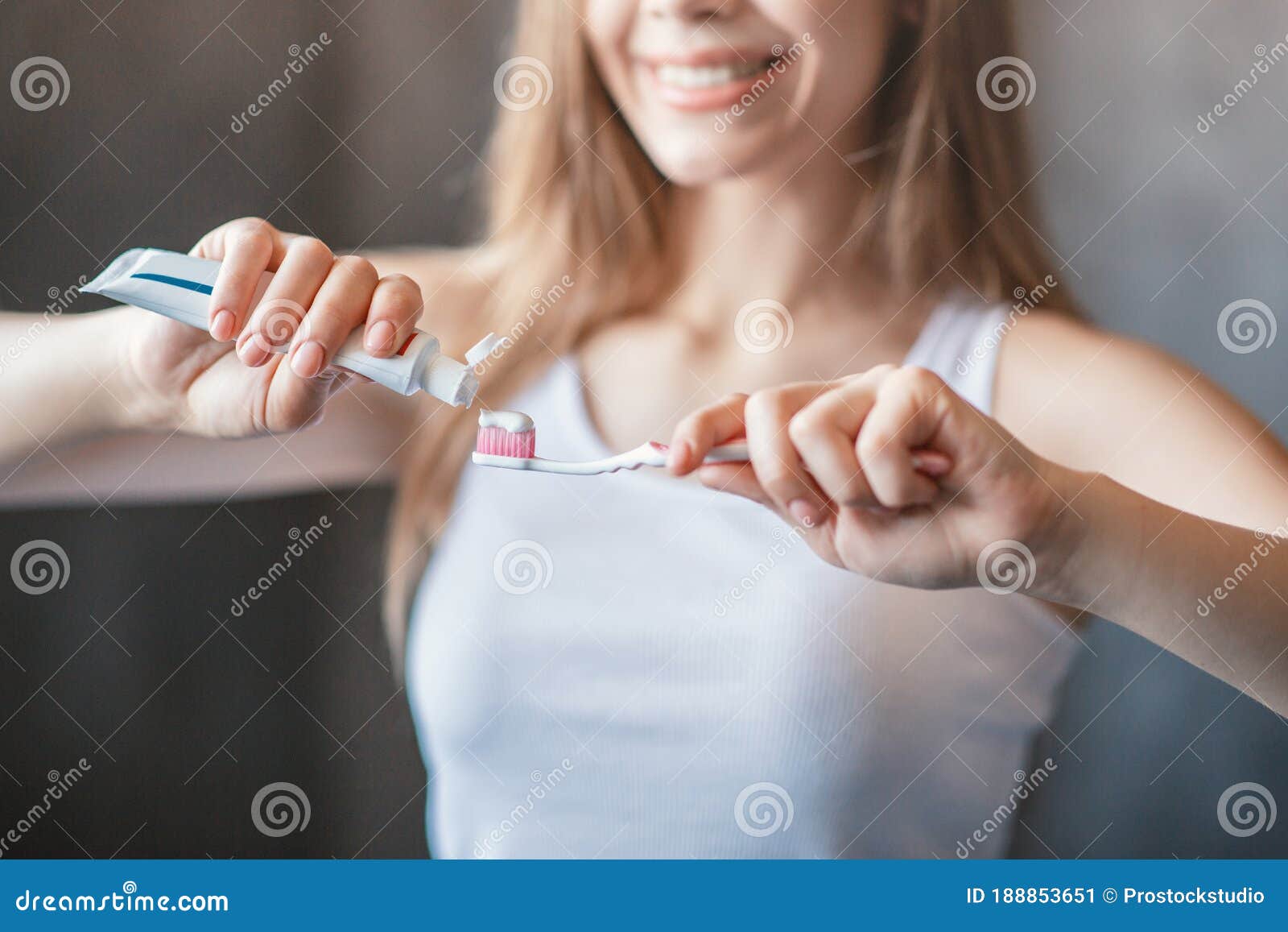 Closeup Of Young Girl Applying Toothpaste From Tube Onto Brush In