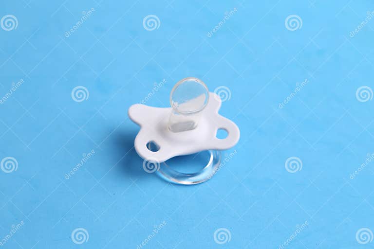 Closeup of a White Pacifier Isolated on a Blue Background Stock Image ...