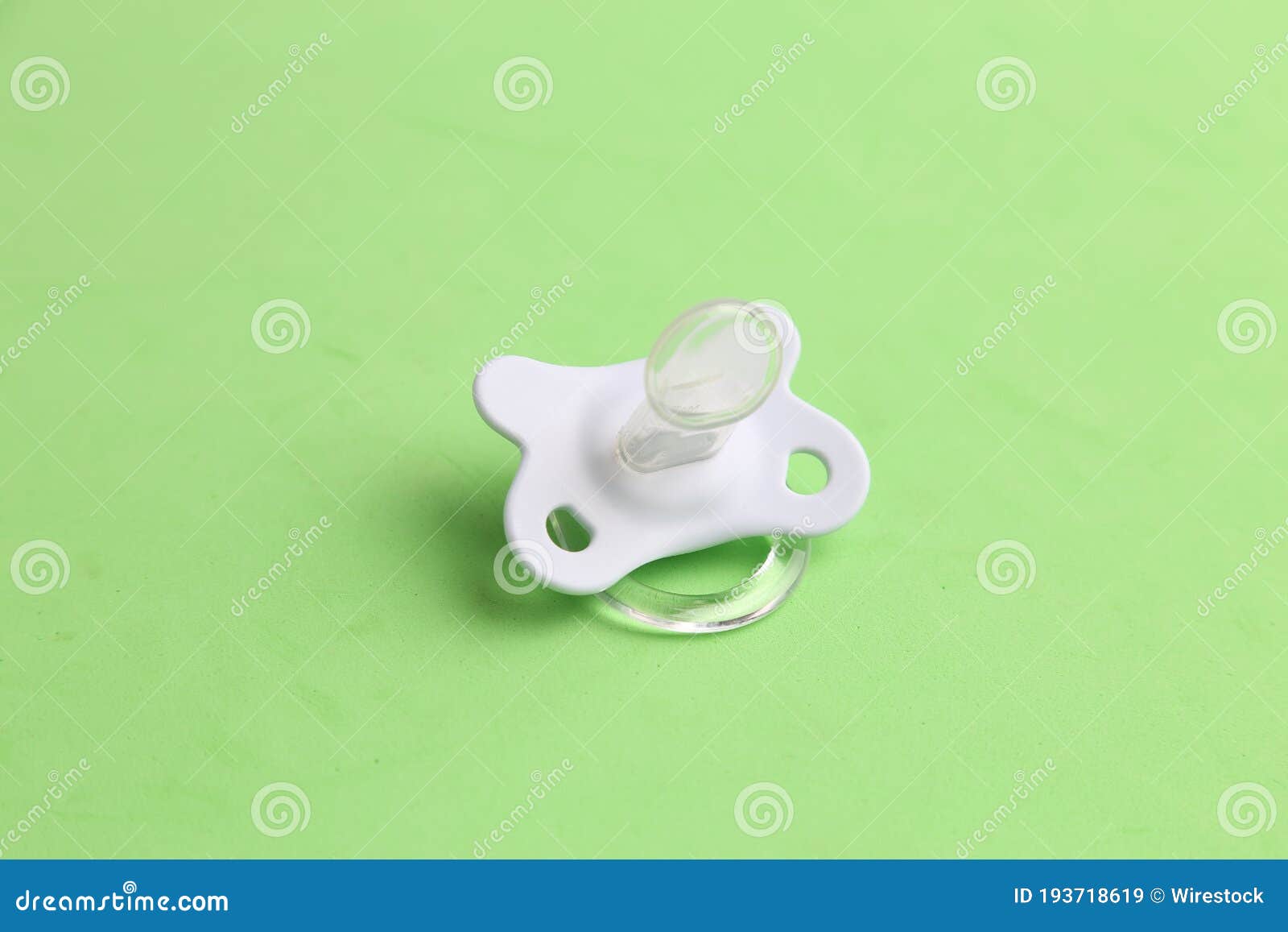 Closeup of a White Pacifier Isolated on a Green Background Stock Image ...