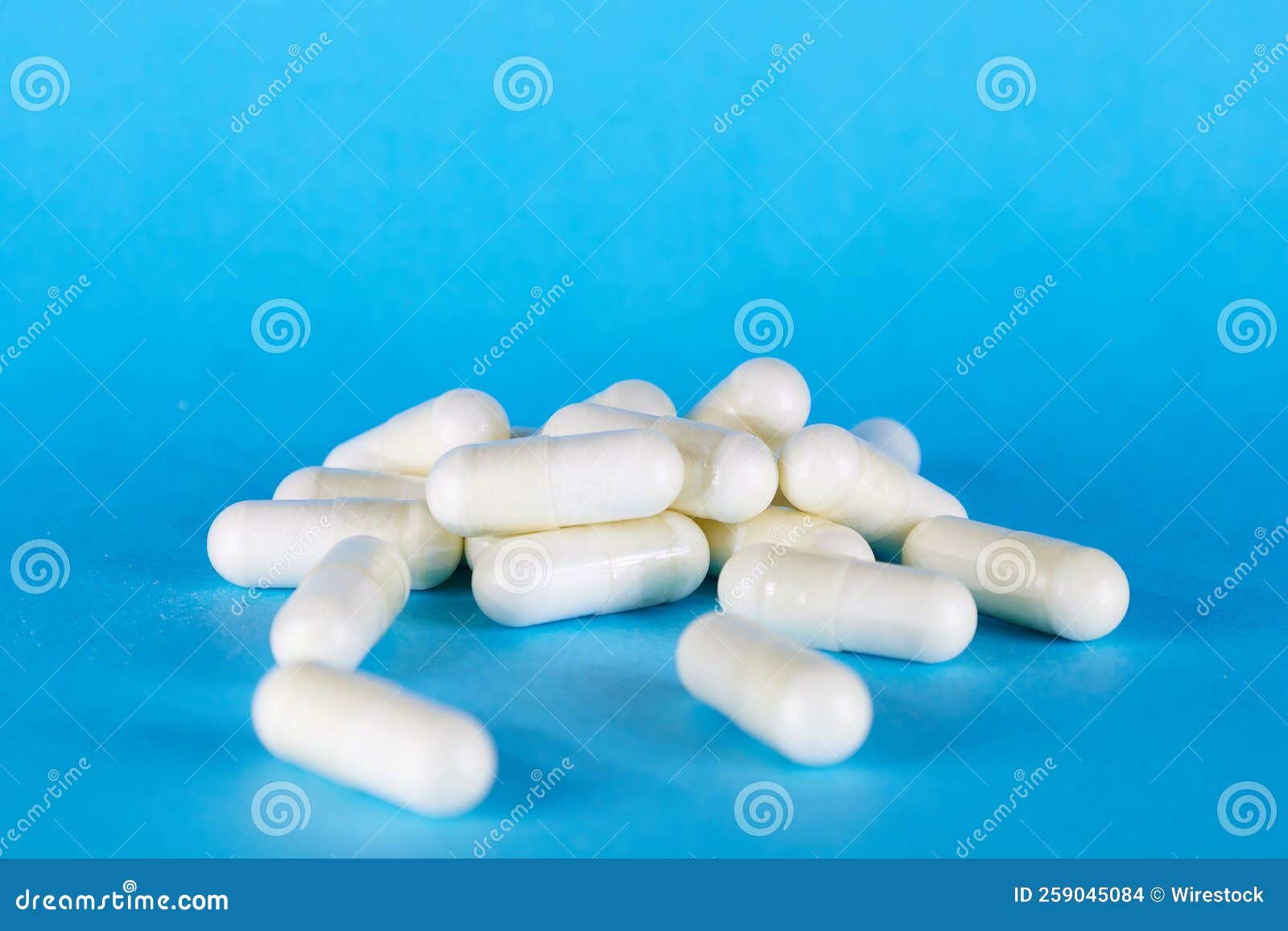 Closeup of White Pill Capsules on Blue Background Stock Photo - Image ...