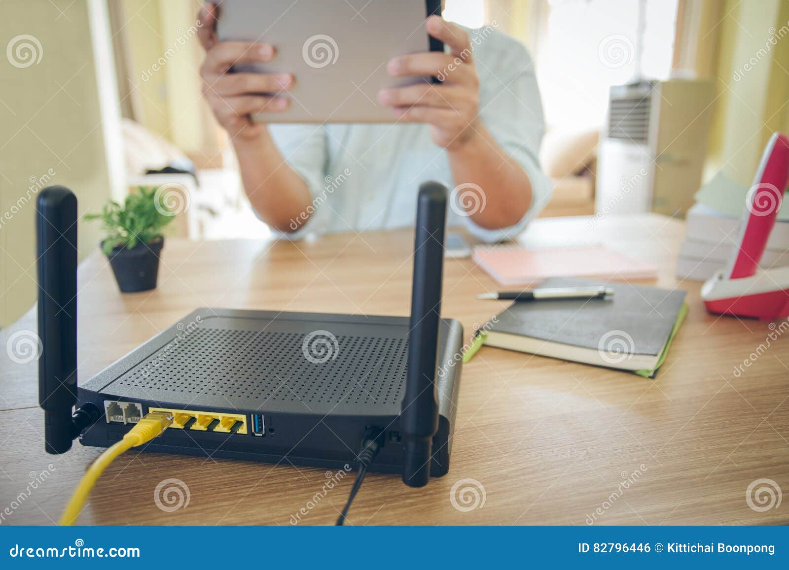 Closeup of a Wireless Router and a Man Using Tablet on Living Room at ...