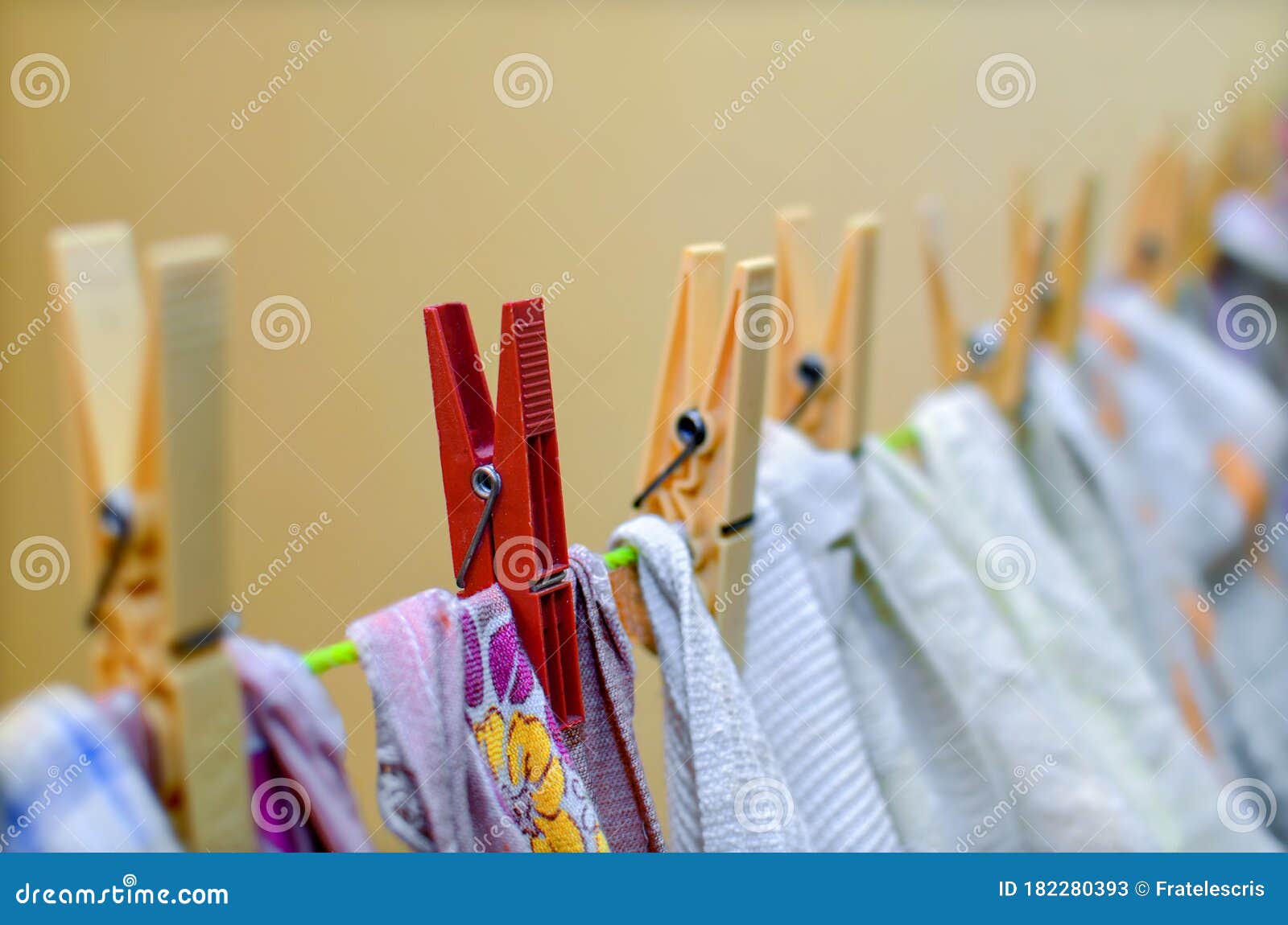 Clothes Pegs on a String Holding Laundry - Yellow Clothes Pins and One ...
