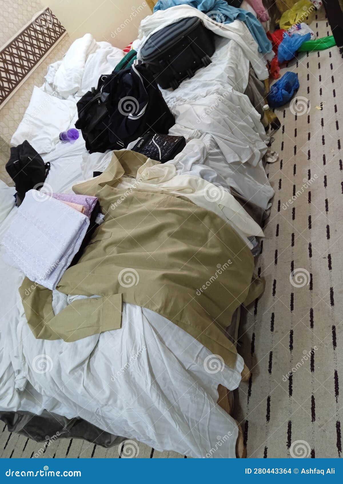 Clothes Scattered Over the Bed in the Hotel Room Stock Photo - Image of ...