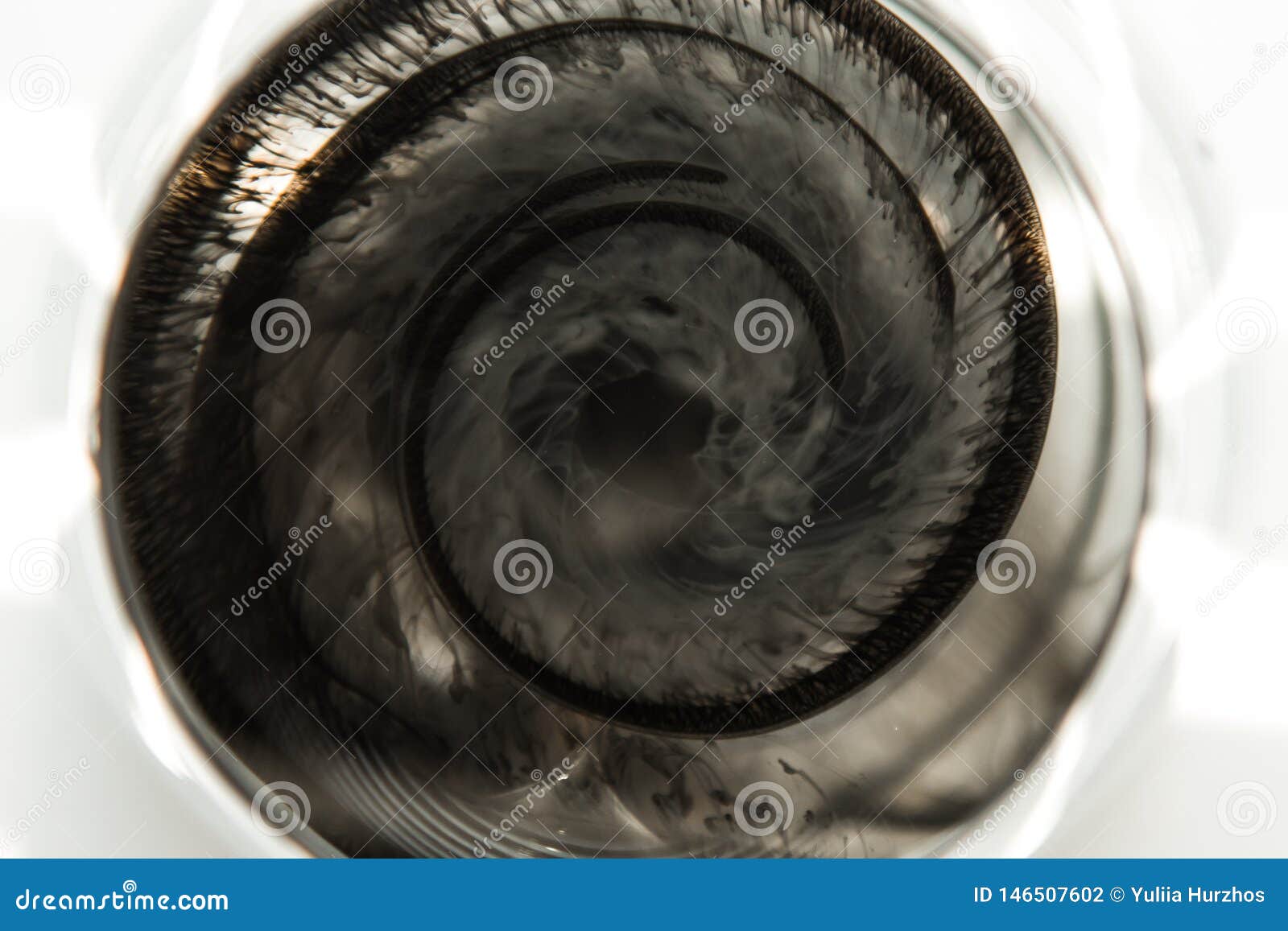 A Cloud of Ink in a Transparent Glass Cup with Clear Water Amid Rays of ...