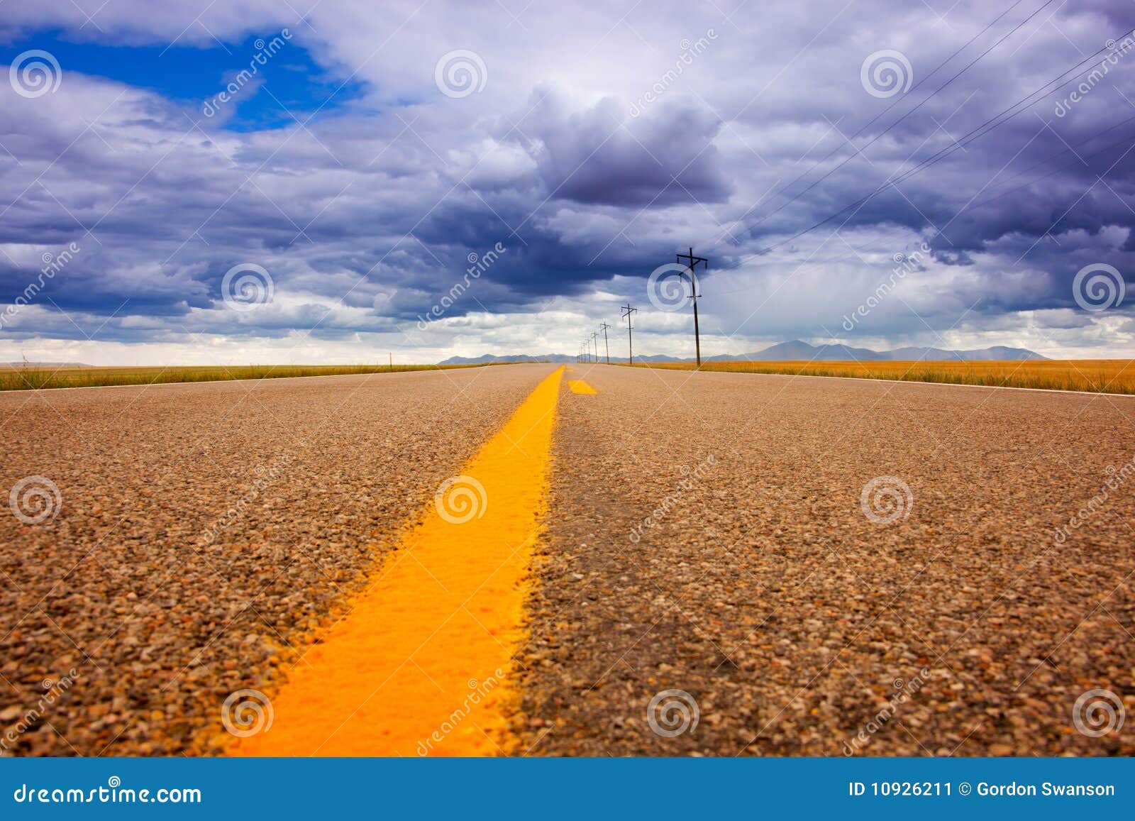 A Highway Receding To Perspective Toward A Mountain Range In A Desert ...