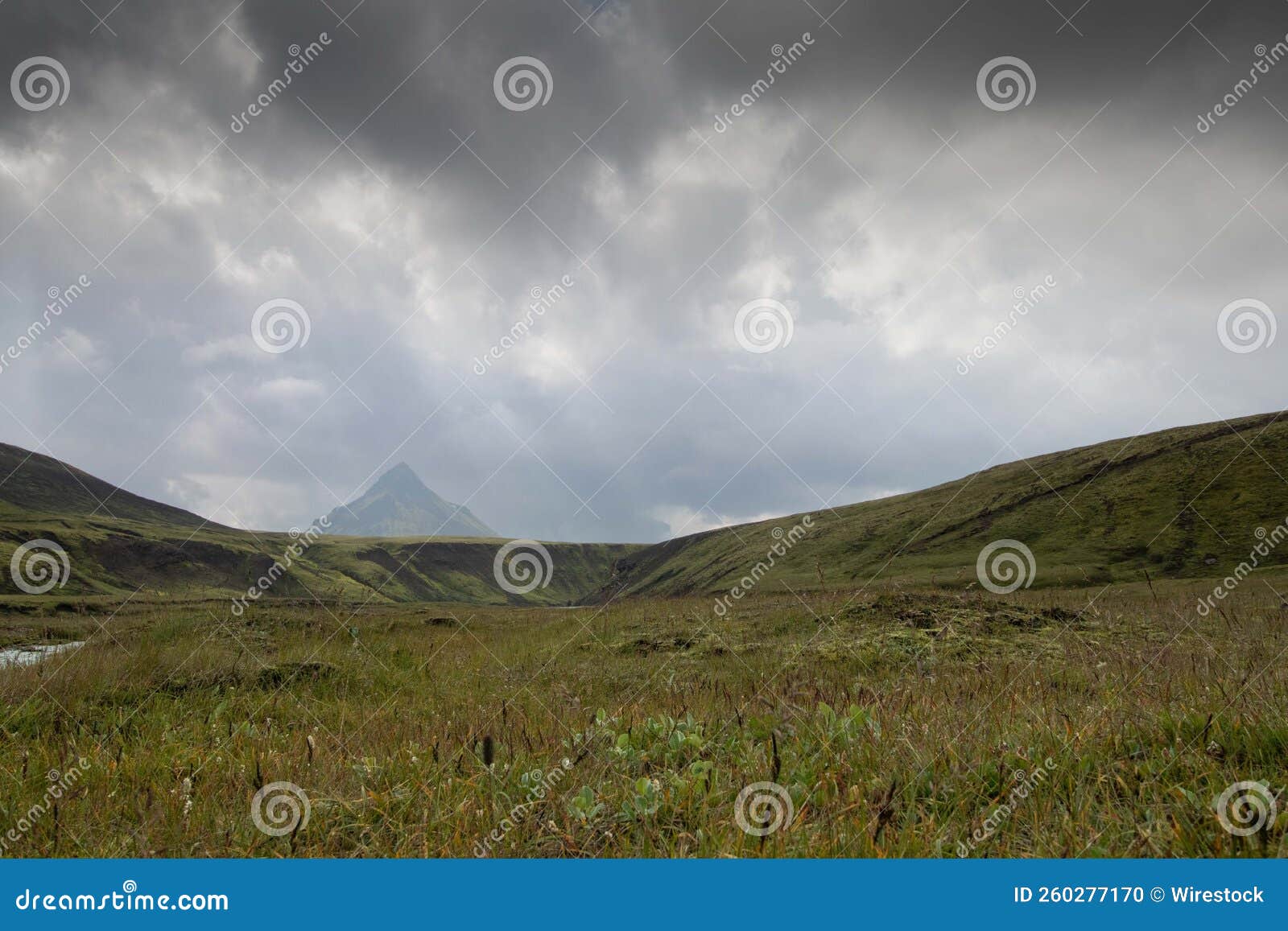 Cloudy Sky Above the Valley with Hills and a Mountain Peak in the ...