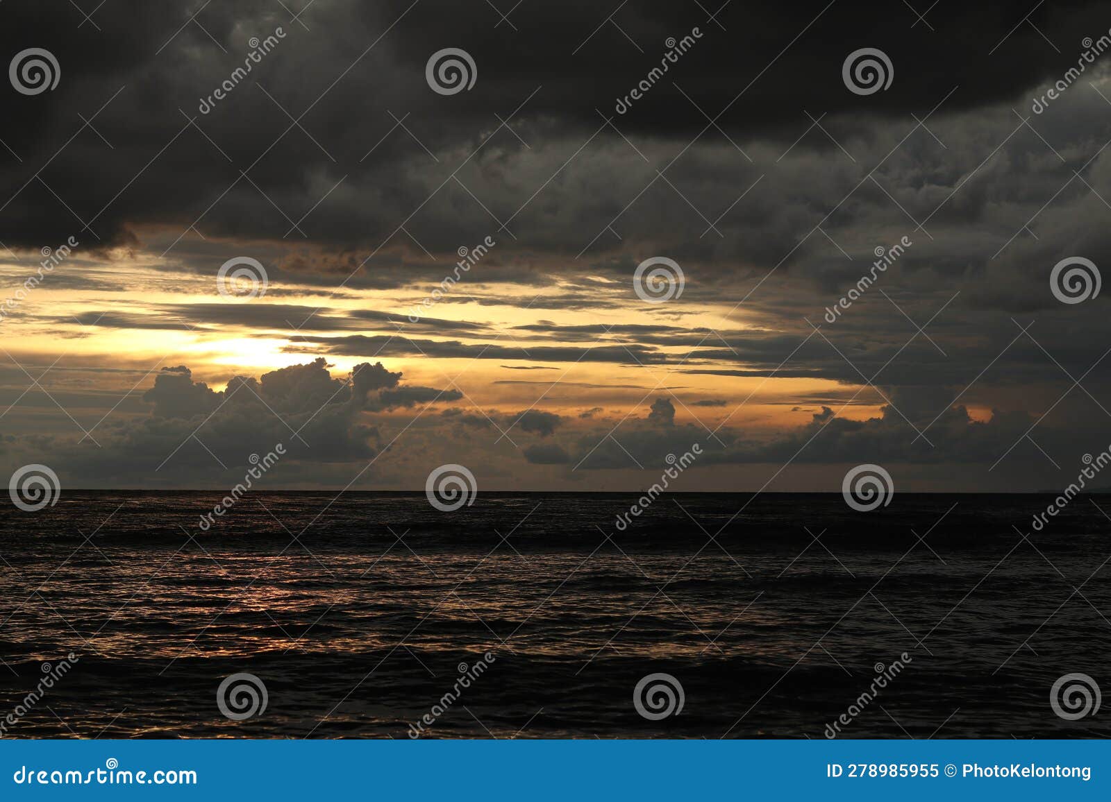 A Cloudy Sky Over the Ocean with a Dark Sky and the Sun Setting Behind ...