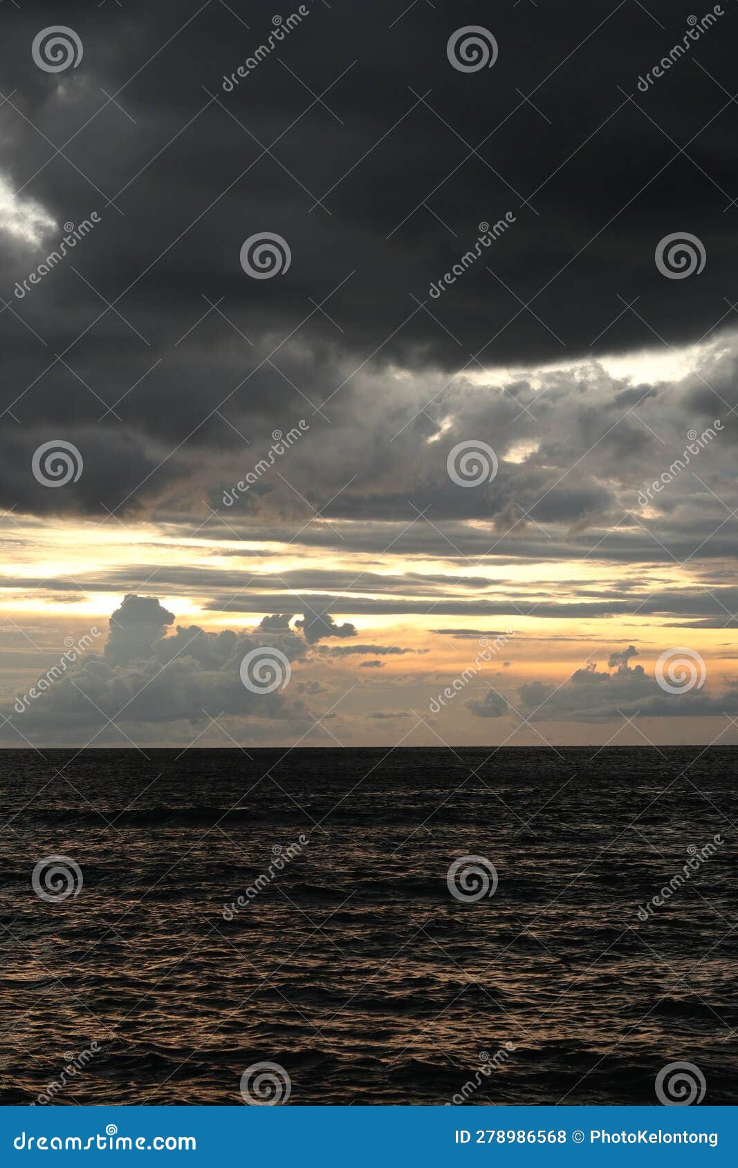 A Cloudy Sky Over the Ocean with a Dark Sky and the Sun Setting Behind ...