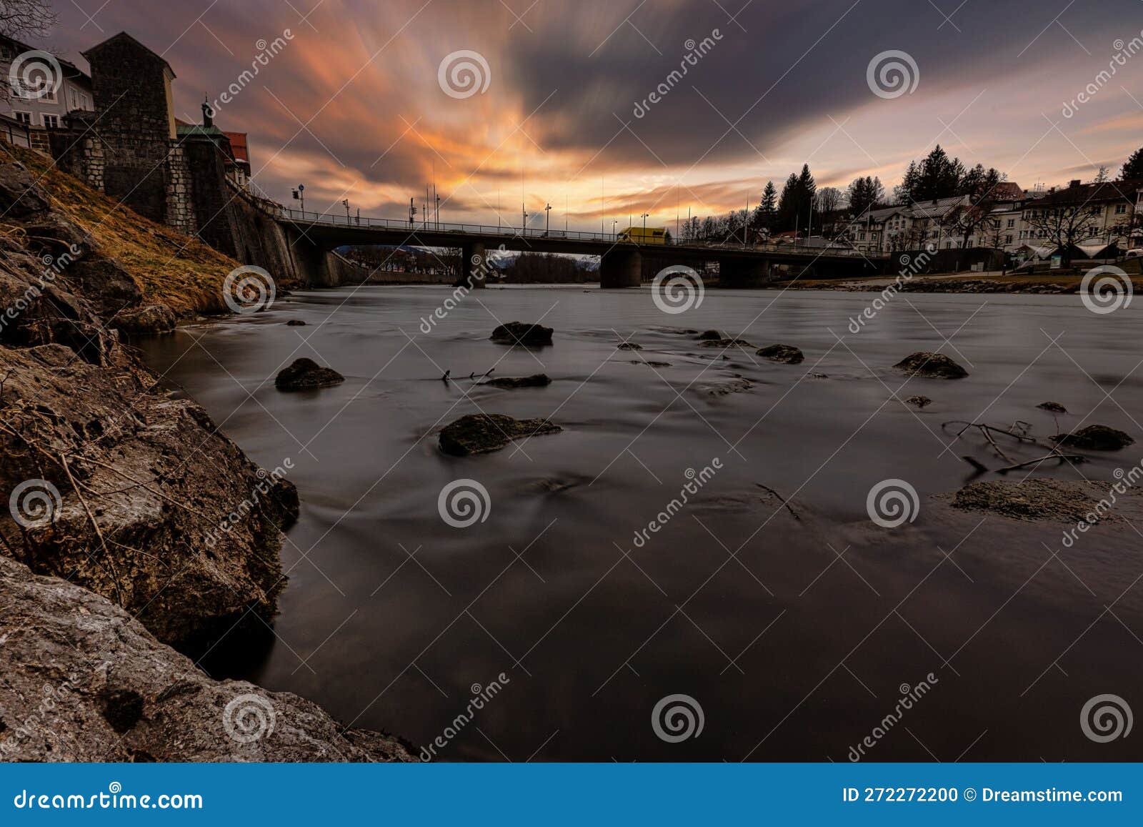 Cloudy Sky at Sunset Over a River with a Bridge, Creating a Somber ...