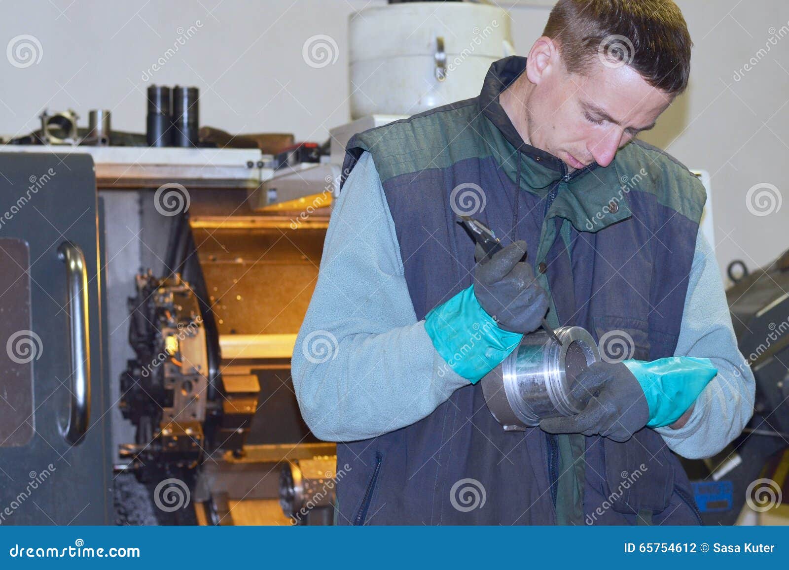 CNC-machinist at Work. he Checks Metal Part Which Was Already Produced ...