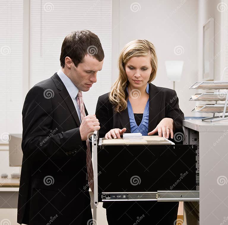 Co-workers Searching through File Drawers Stock Photo - Image of ...