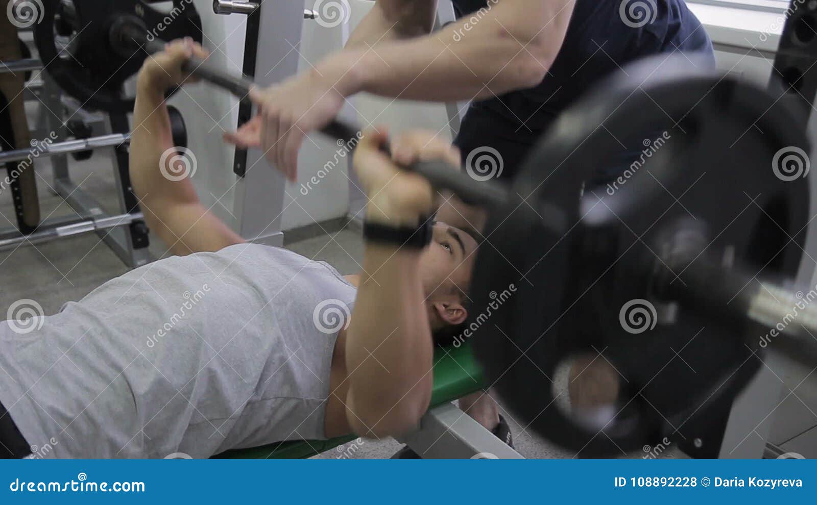 Coach Helps Bodybuilder To Do an Exercise with the Bar Lying Down ...