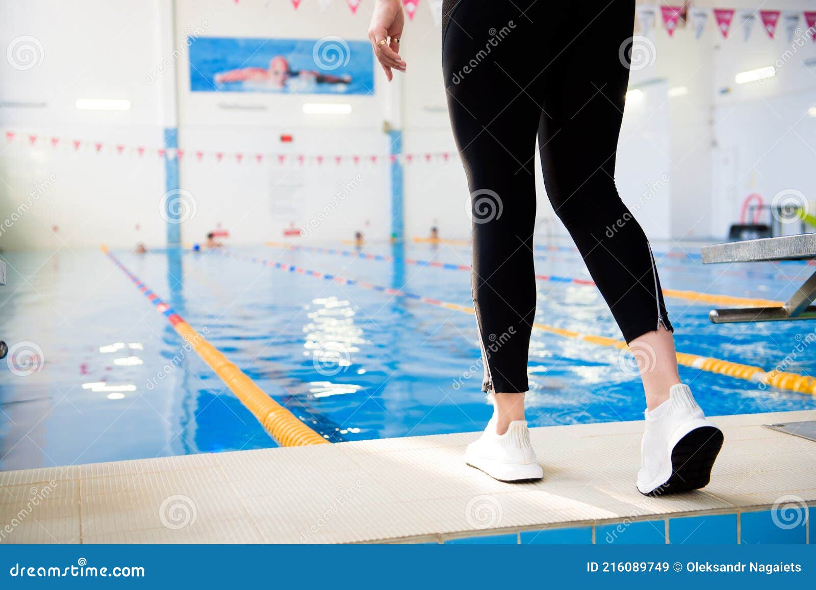A Coach Stands at the Edge of the Pool and Oversees the Swimming ...