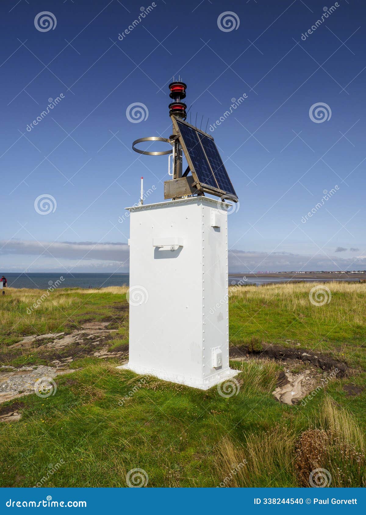 Coastal Beacon with Solar Panel Under a Clear Blue Sky on a Grassy ...
