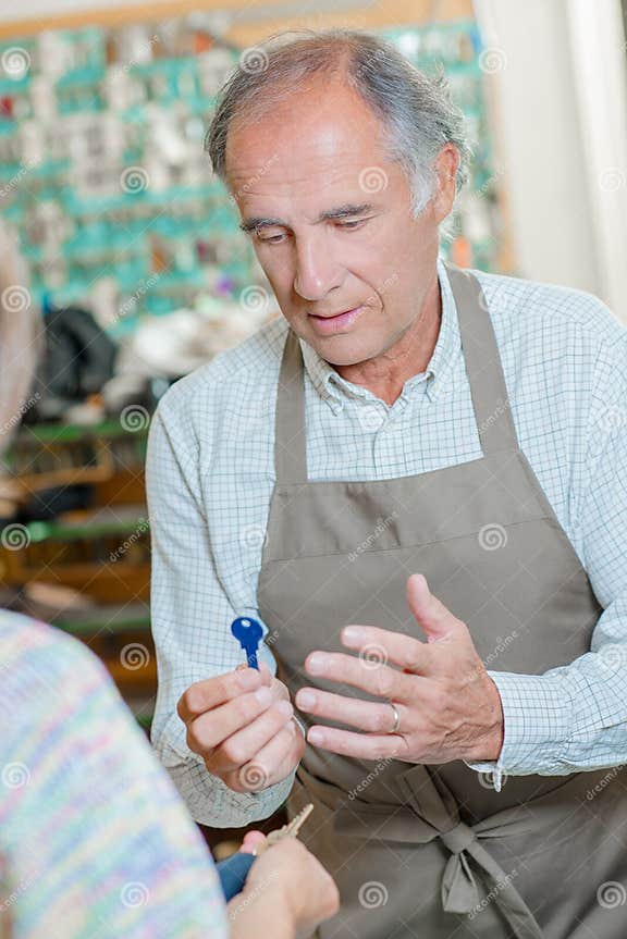 Cobbler holding key stock image. Image of shop, shirt - 289040837