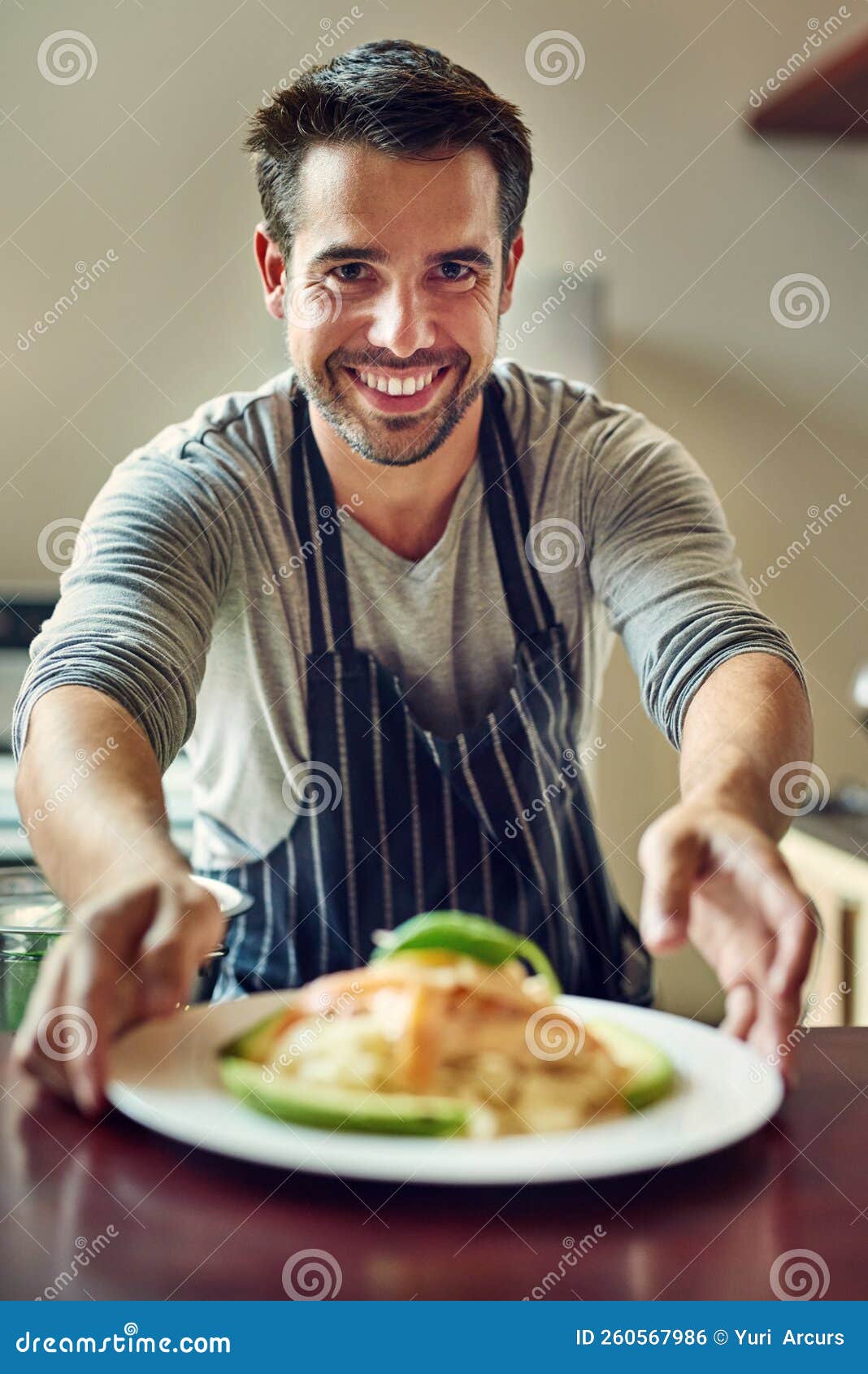 Cocinar Es Comestible Un Joven Sirviendo Comida En La Cocina En Casa Foto De Archivo Imagen