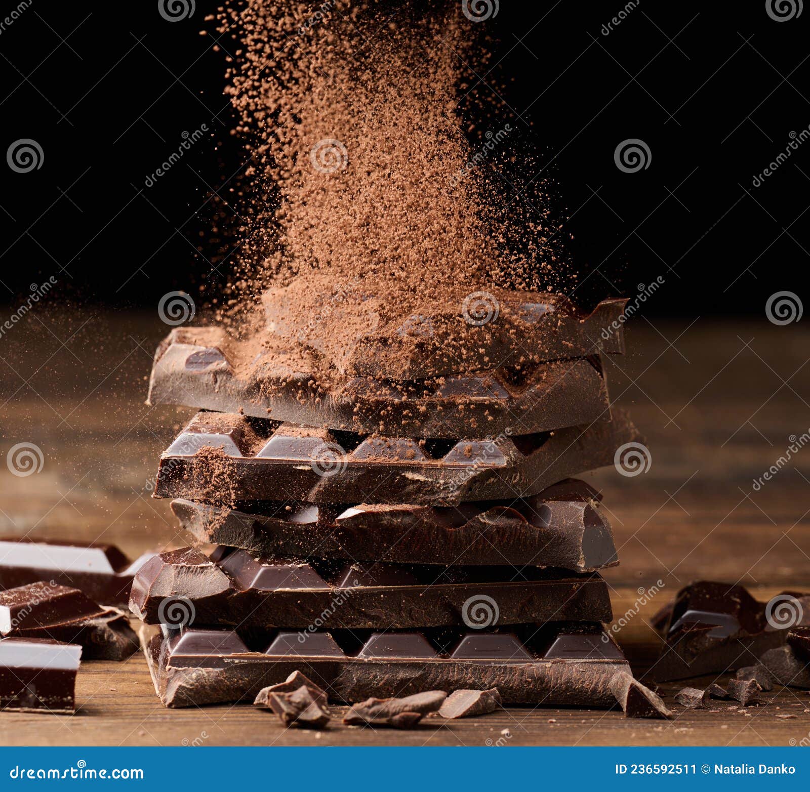 Cocoa Powder Sprinkles on a Stack of Broken Dark Chocolate on a Wooden ...