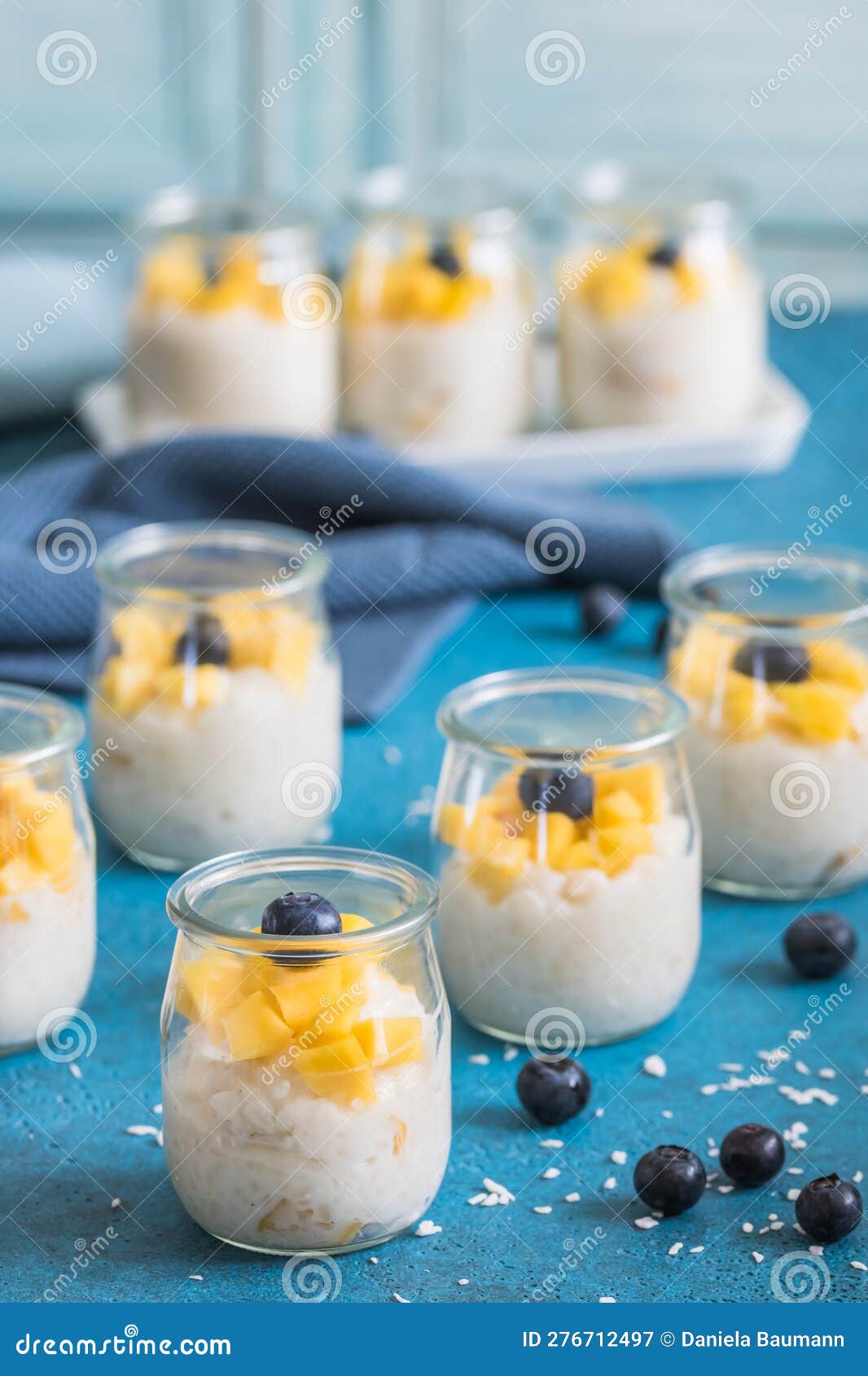 Coconut Rice Pudding with Mango in Dessert Glasses on Blue Background ...