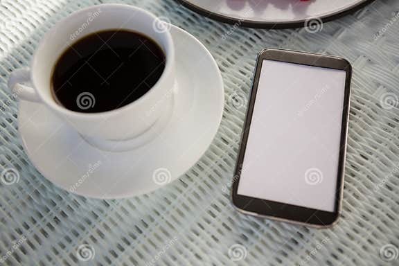 Coffee Cup by Mobile Phone on Table at Cafe Stock Photo - Image of ...
