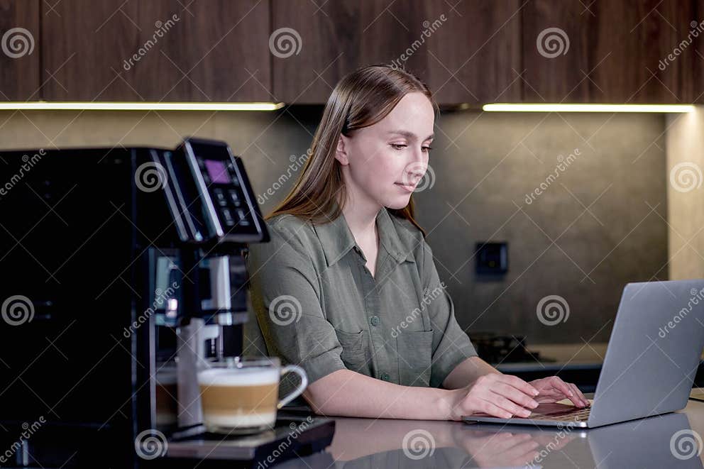 Coffee Machine Prepares Coffee while the Woman Working at the Computer ...