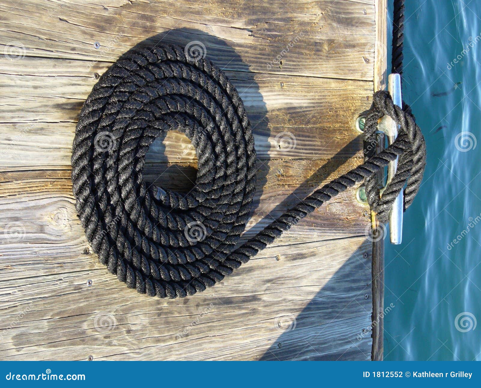 Coiled black rope on dock stock photo. Image of knot, ocean - 1812552