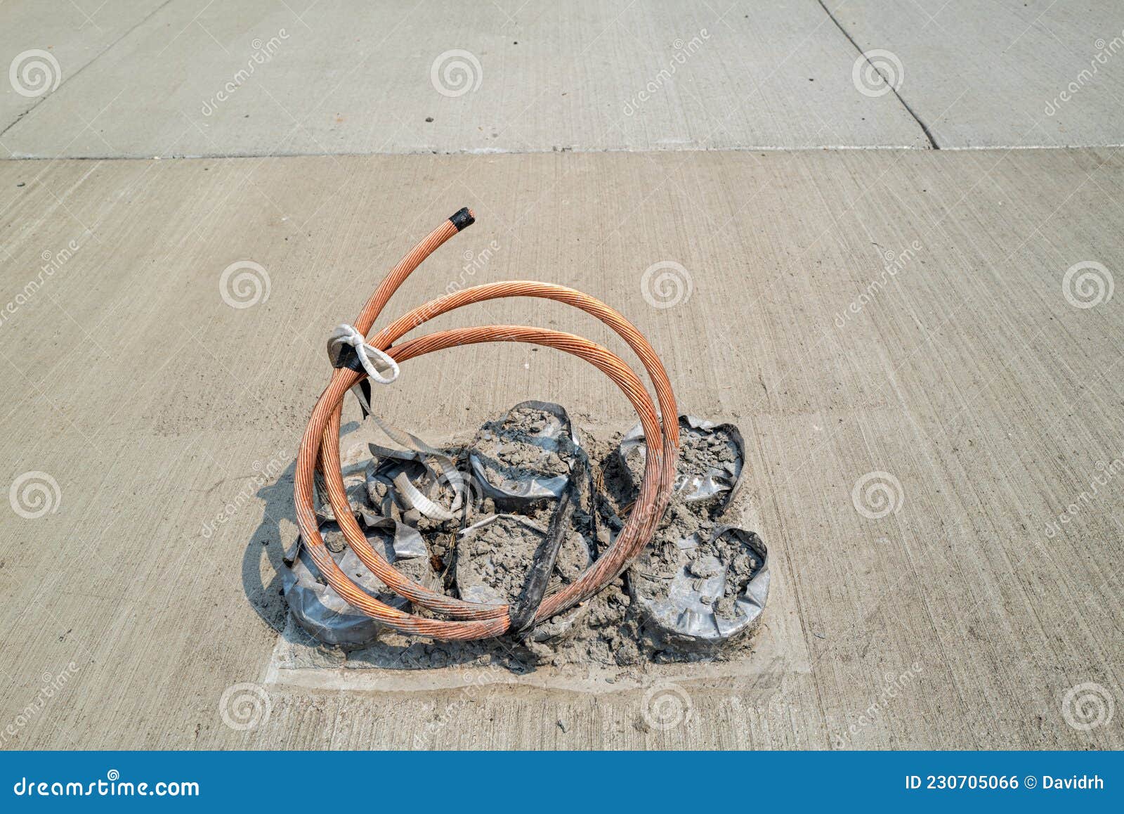 Coiled Copper Wire Sticking Out of Concrete on the Ground Stock Photo ...