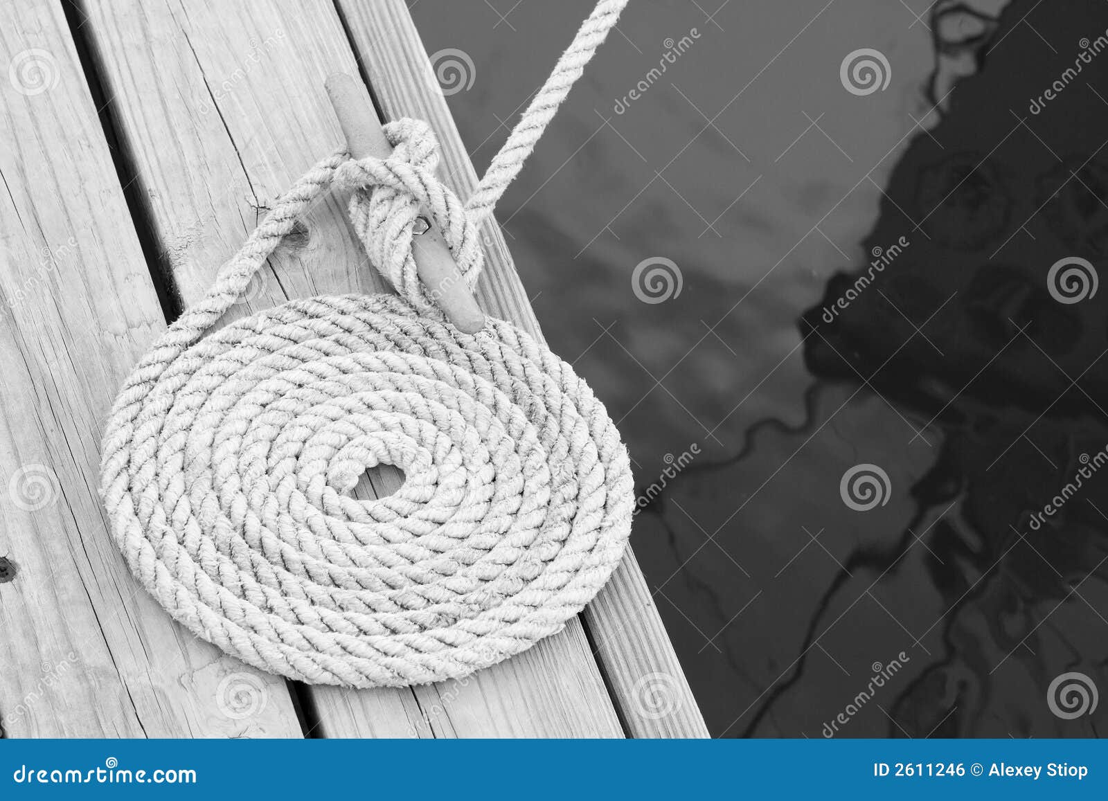 Coiled Mooring Line Tied Around Cleat On A Wooden Dock. Royalty-Free ...