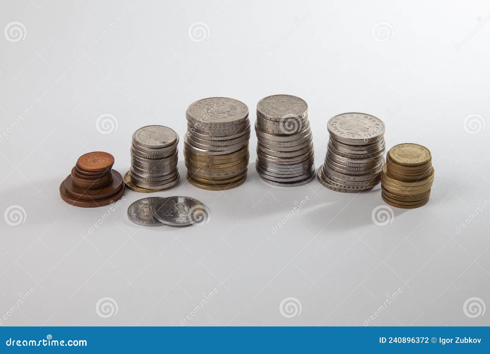Coins of Different Countries Stacked in Piles on a White Background ...