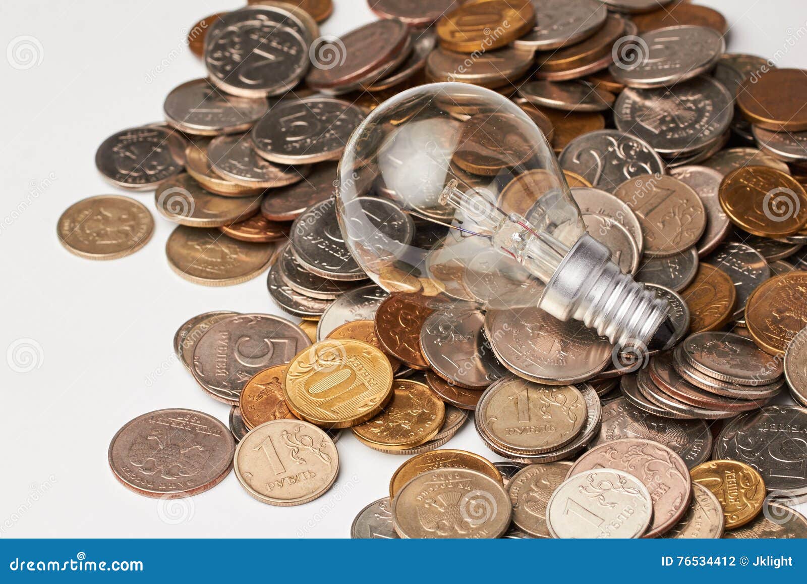 Coins and a light bulb. stock photo. Image of income - 76534412