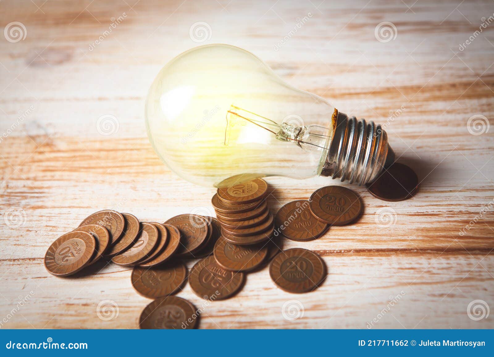 Coins and light bulb stock photo. Image of glow, coins - 217711662