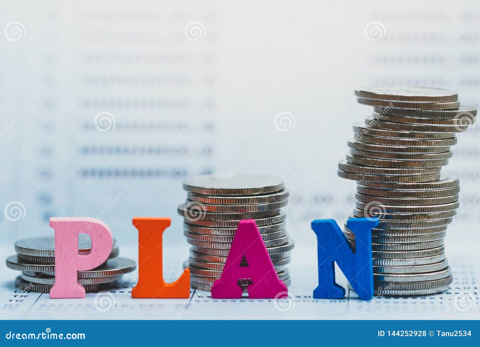 Coins Stacking and Wooden Blocks with the Text PLAN on Bank Passbook ... Coins Stacking and Wooden Blocks with the Text PLAN on Bank Passbook ...