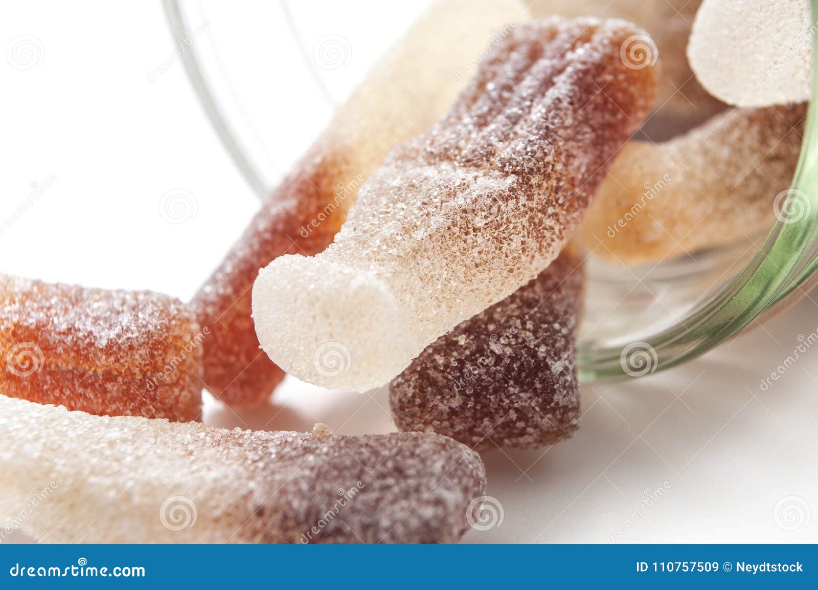 Cola Candies Falling from Glass Container on White Ba Stock Image ...