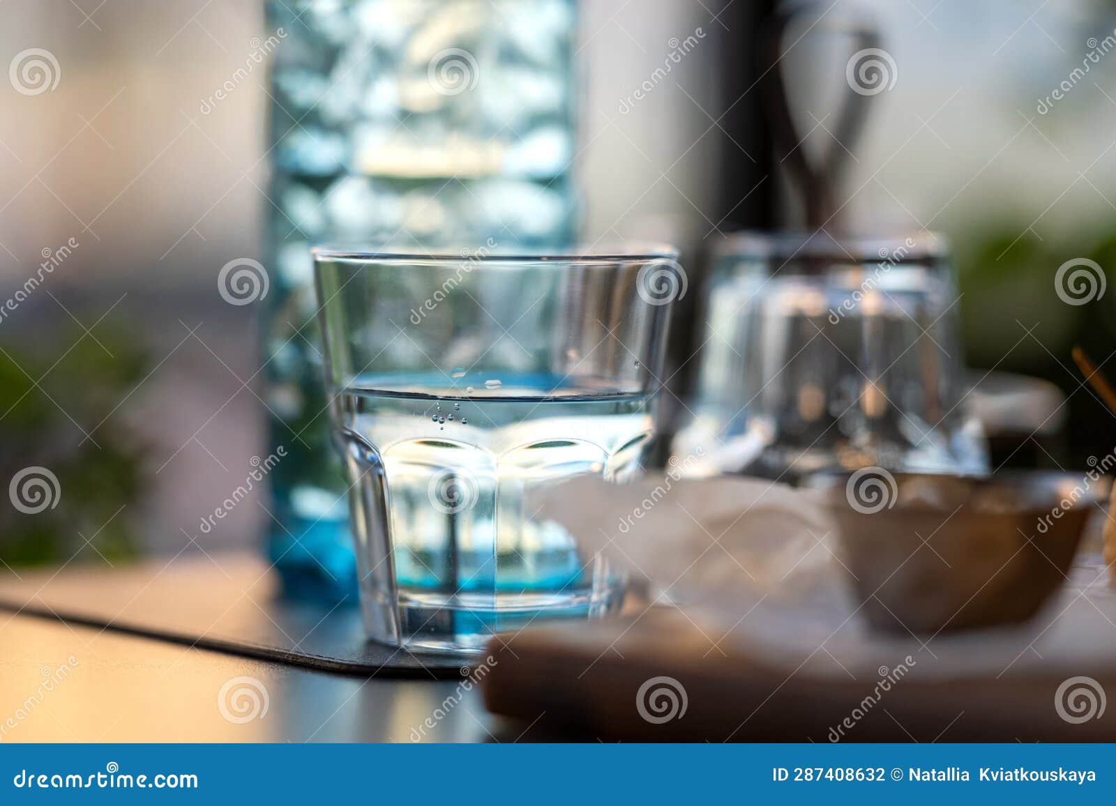 Cold Fresh Water in Old-fashioned Bottle with Glasses on a Cafe Table ...
