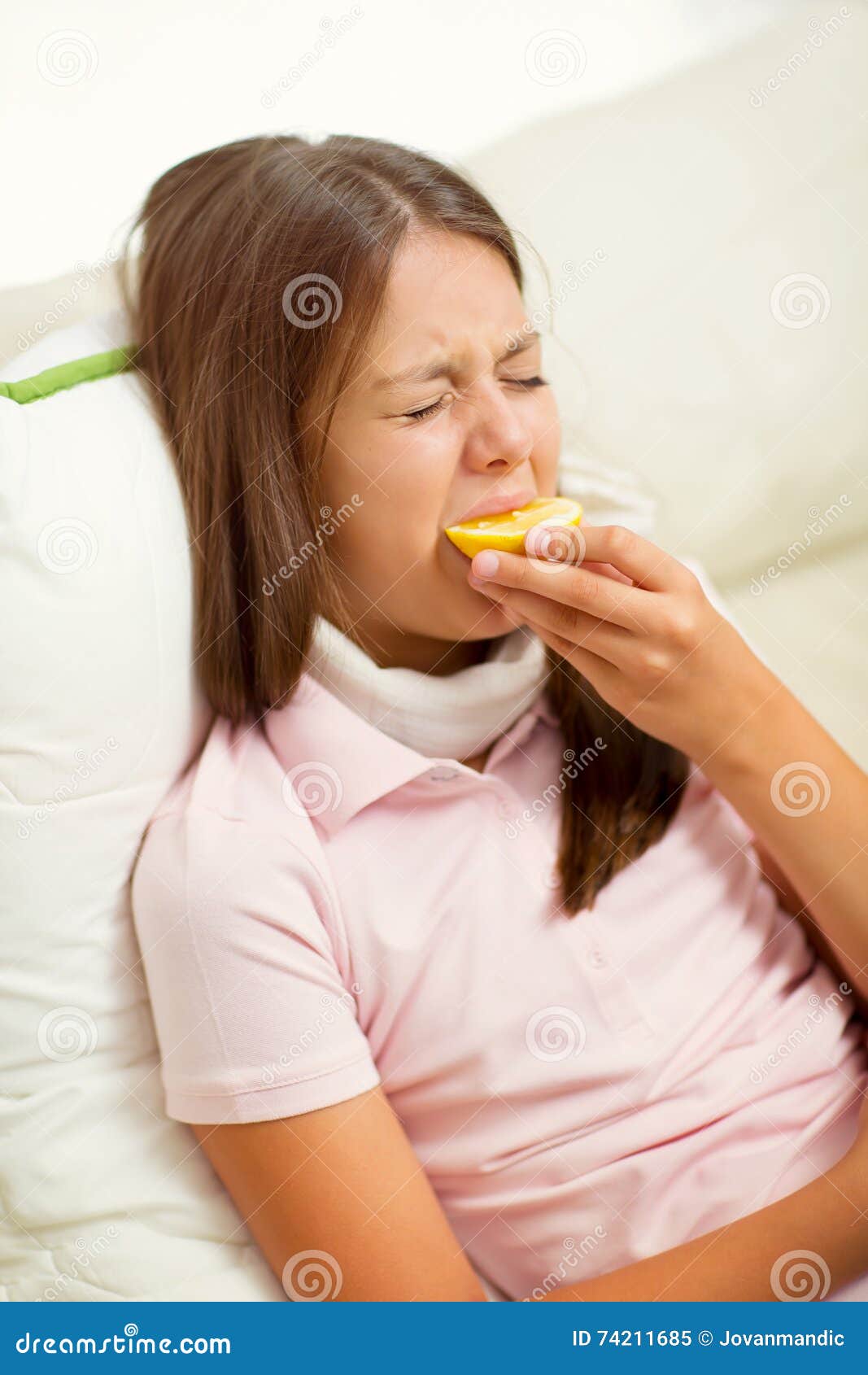 Cold girl eating a lemon stock image. Image of check - 74211685