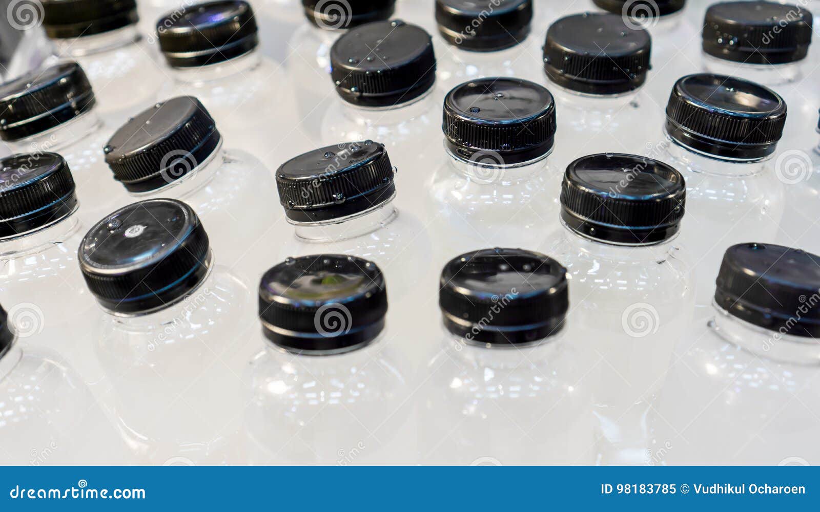Cold Water Bottles with Black Caps in Ice Box. Stock Image - Image of ...