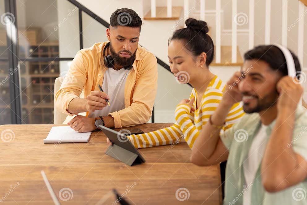 Collaborating on Project, Young Friends Using Tablet and Notebook at ...