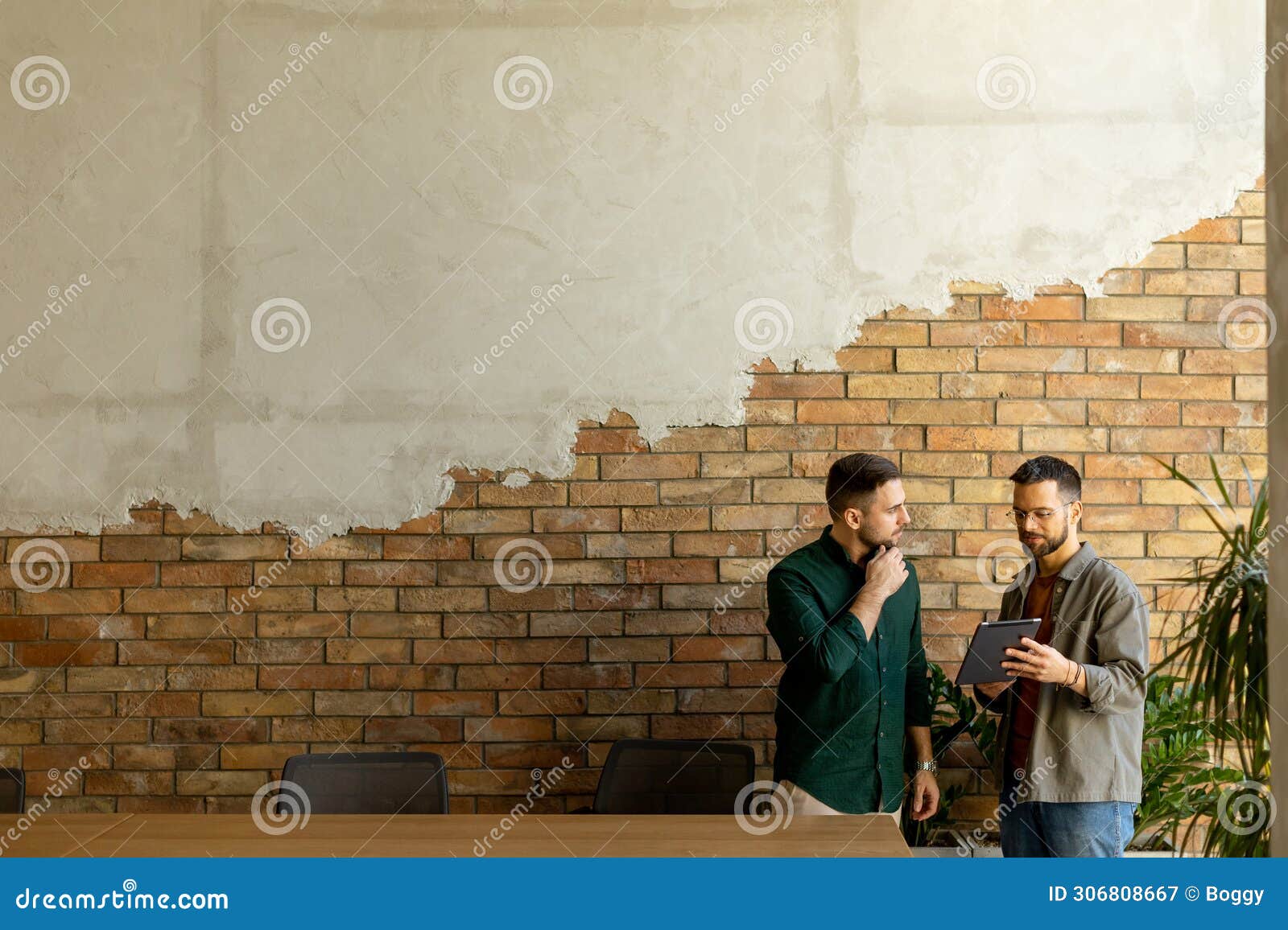 Collaborative Discussion in a Modern Office with Exposed Brick Walls ...