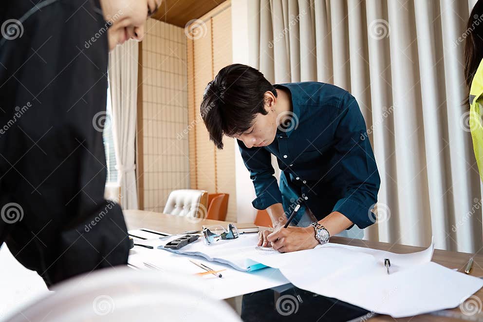 Collaborative Engineers Working on Architectural Blueprint and ...