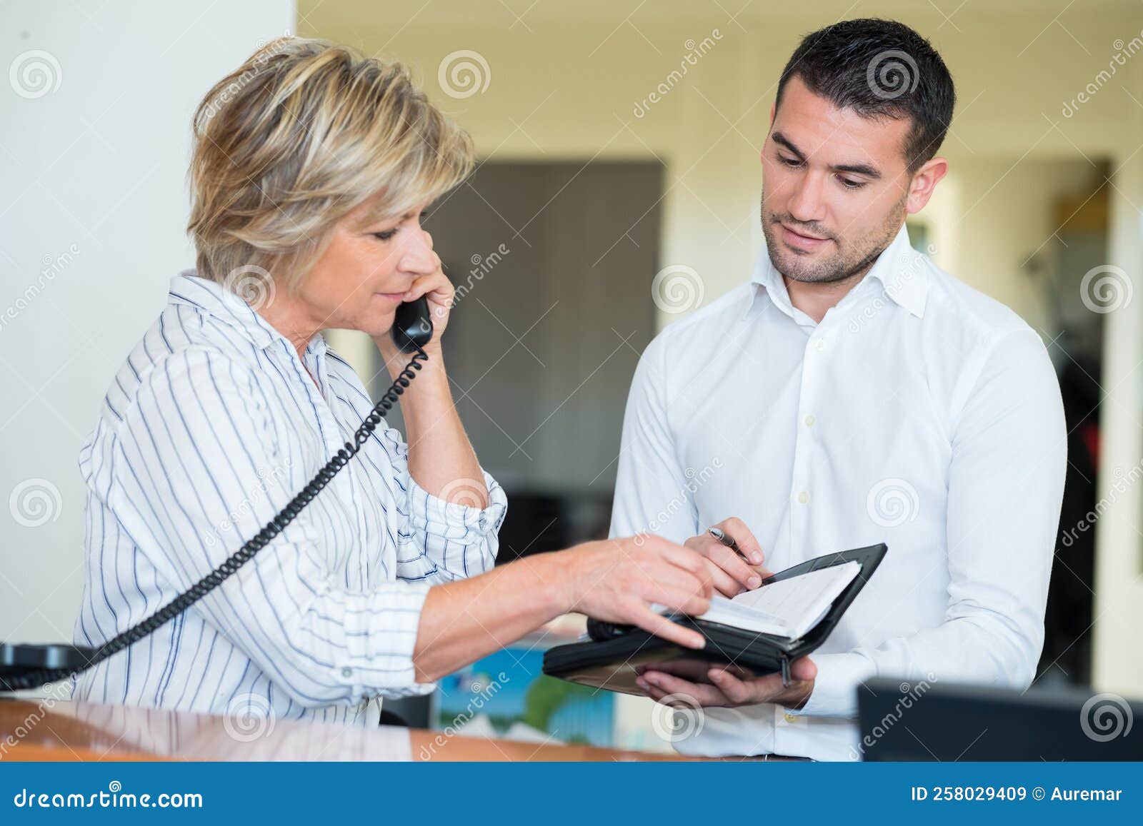 Colleagues Consulting Diary while Woman Talks on Telephone Stock Image ...