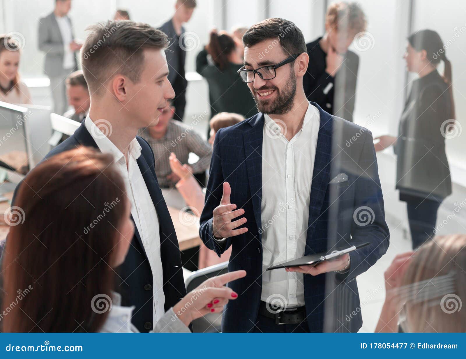 Colleagues Discussing Current Tasks Standing in the Office Stock Image ...