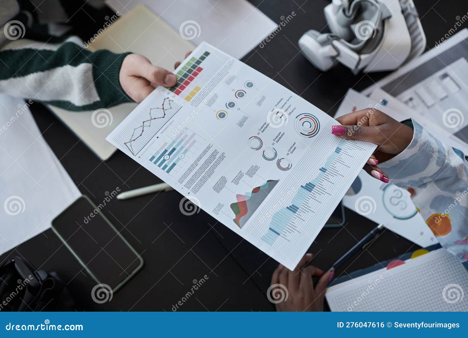 Colleagues Examining Document with Graphs Stock Photo - Image of office ...