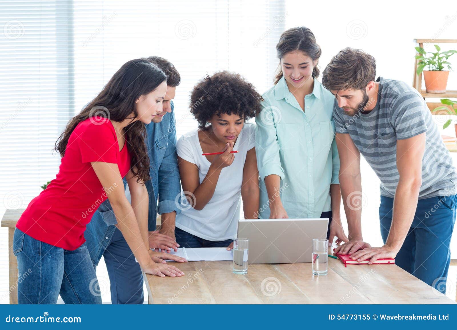 Colleagues Gathered Around a Laptop at Office Stock Image - Image of ...