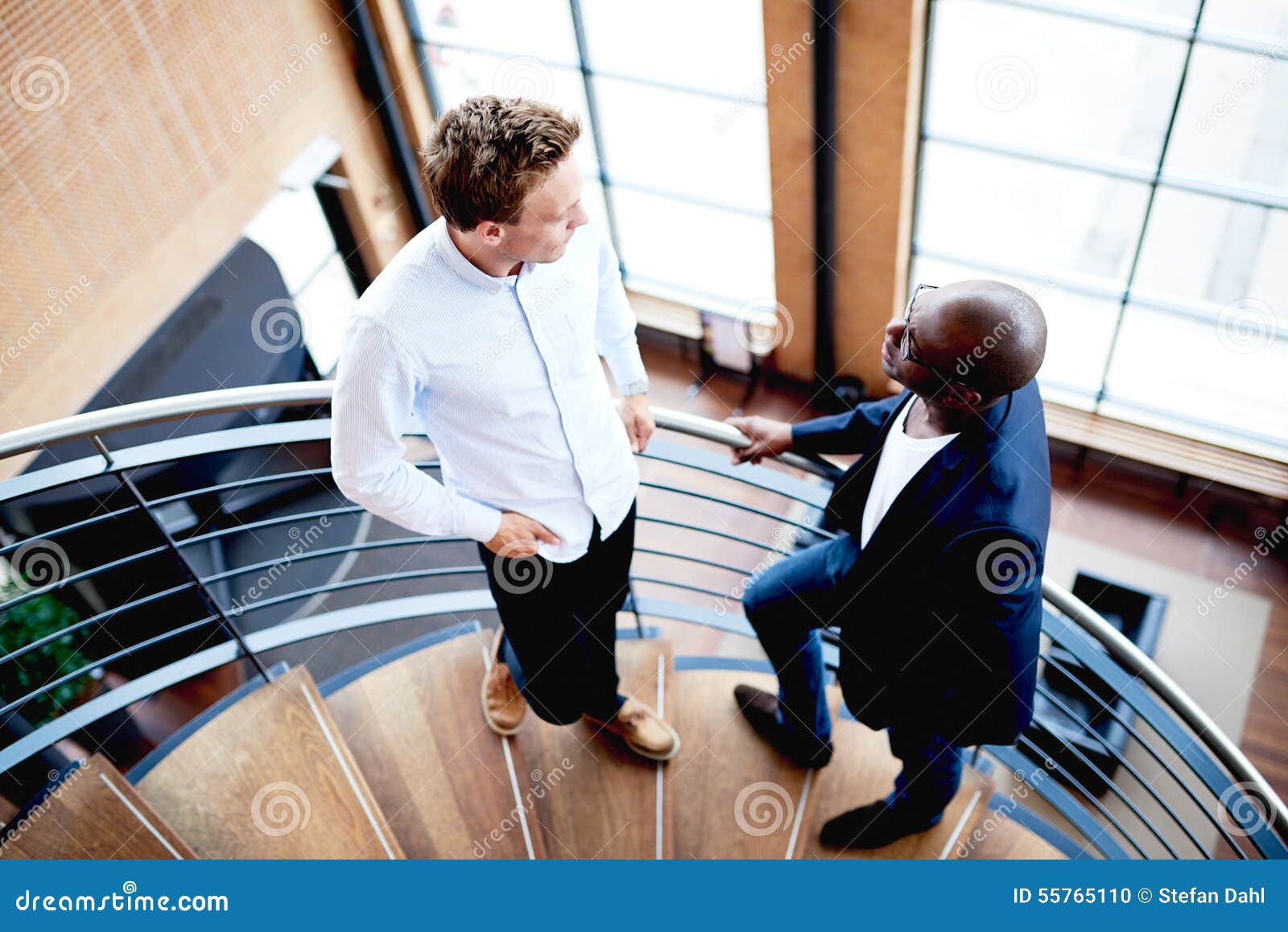 Colleagues Interacting at Work Standing on Staircase Stock Photo ...