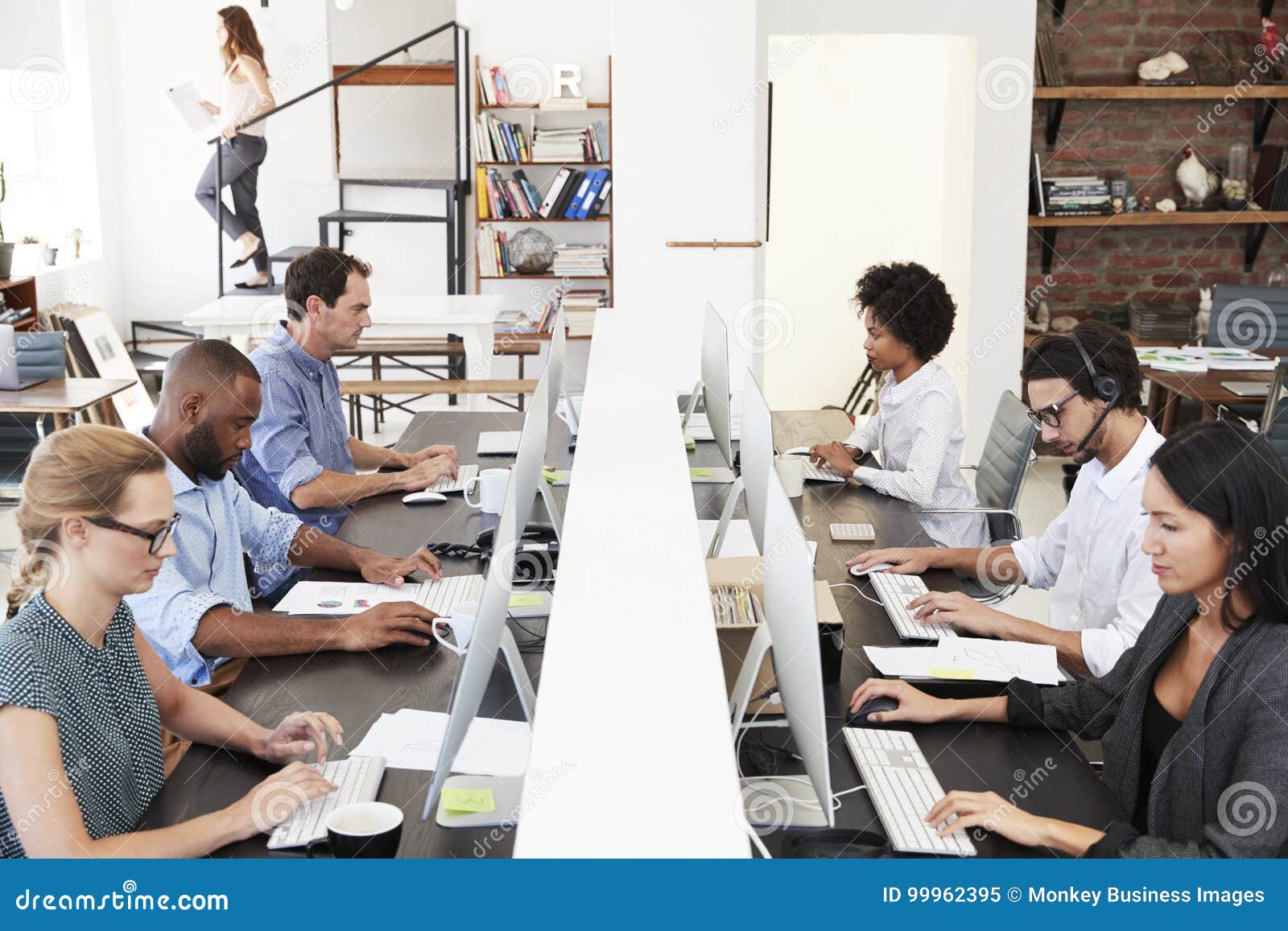 Colleagues Sit Using Computers in a Busy Open Plan Office Stock Image ...