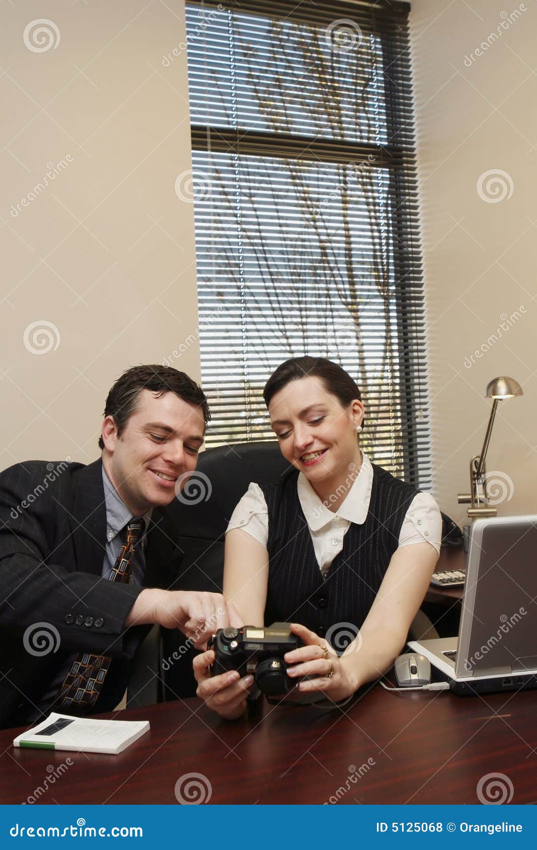 Colleagues Smiling at Photos - Vertical Stock Photo - Image of ...