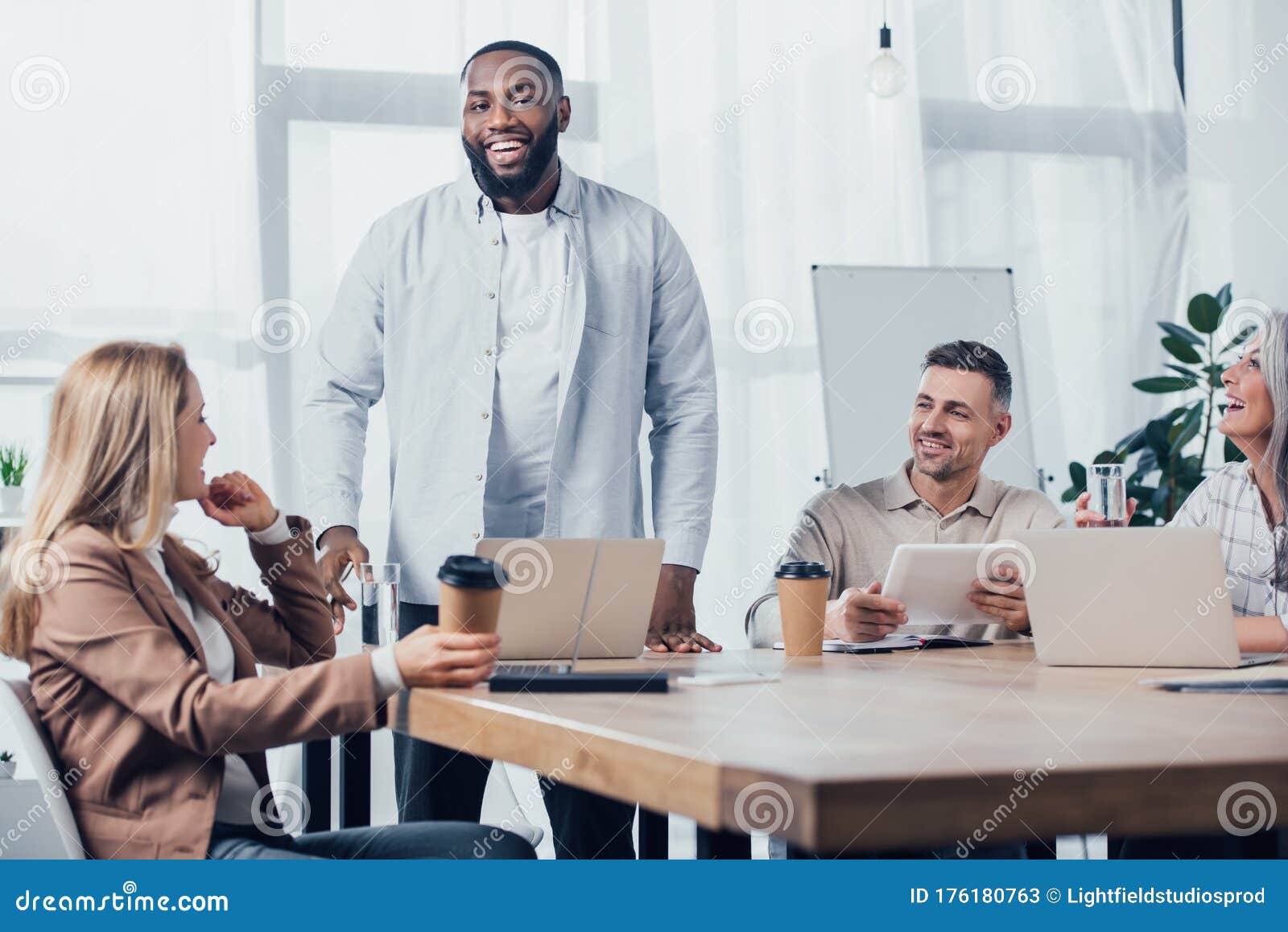 Colleagues Smiling and Sitting at Table Stock Image - Image of ...