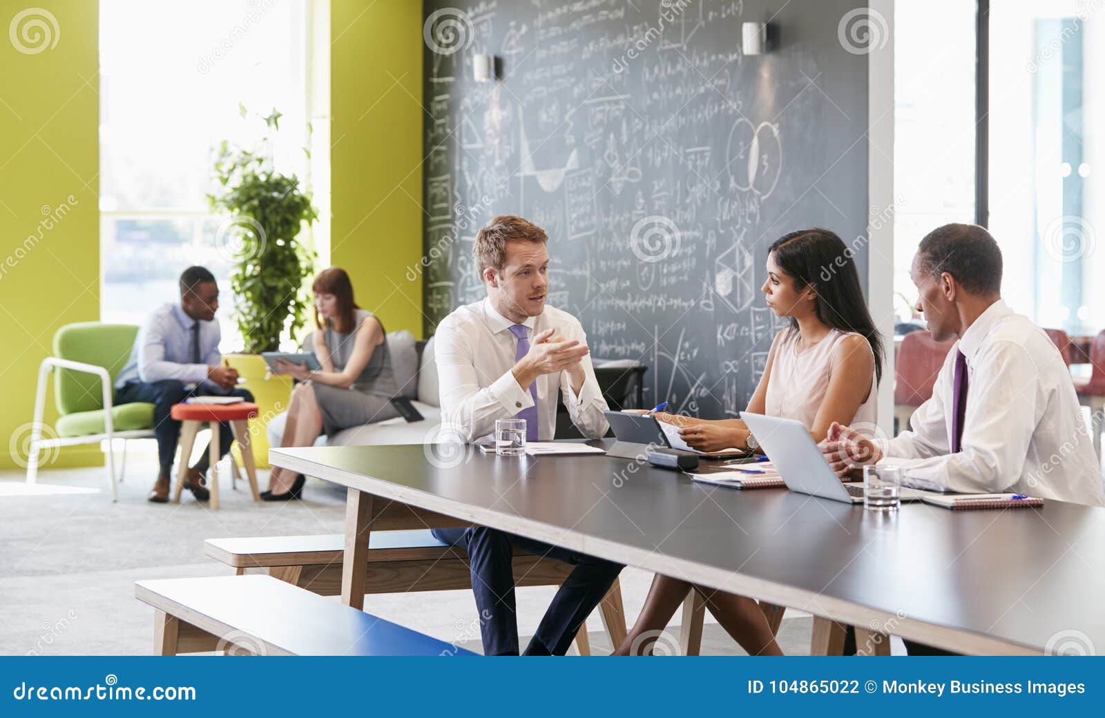 Colleagues Talking at Work in an Informal Meeting Area Stock Photo ...