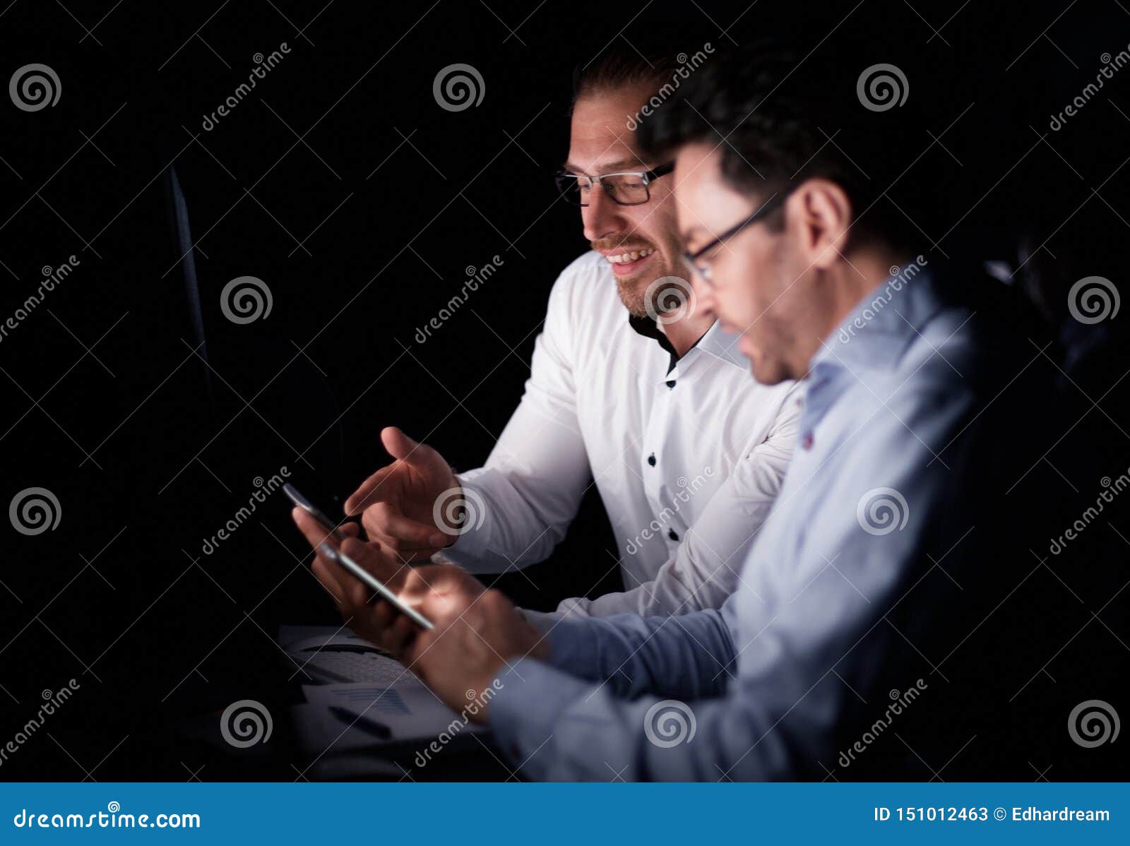 Colleagues Using Smartphones while Sitting at a Desk Stock Image ...