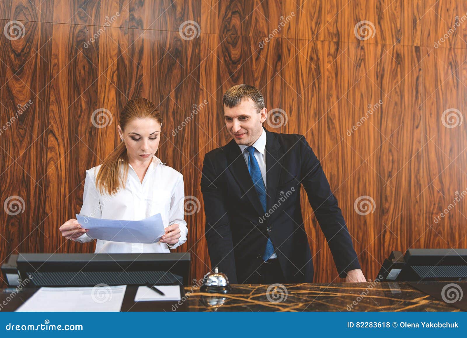 Colleagues Viewing Documentation at Reception Stock Photo - Image of ...